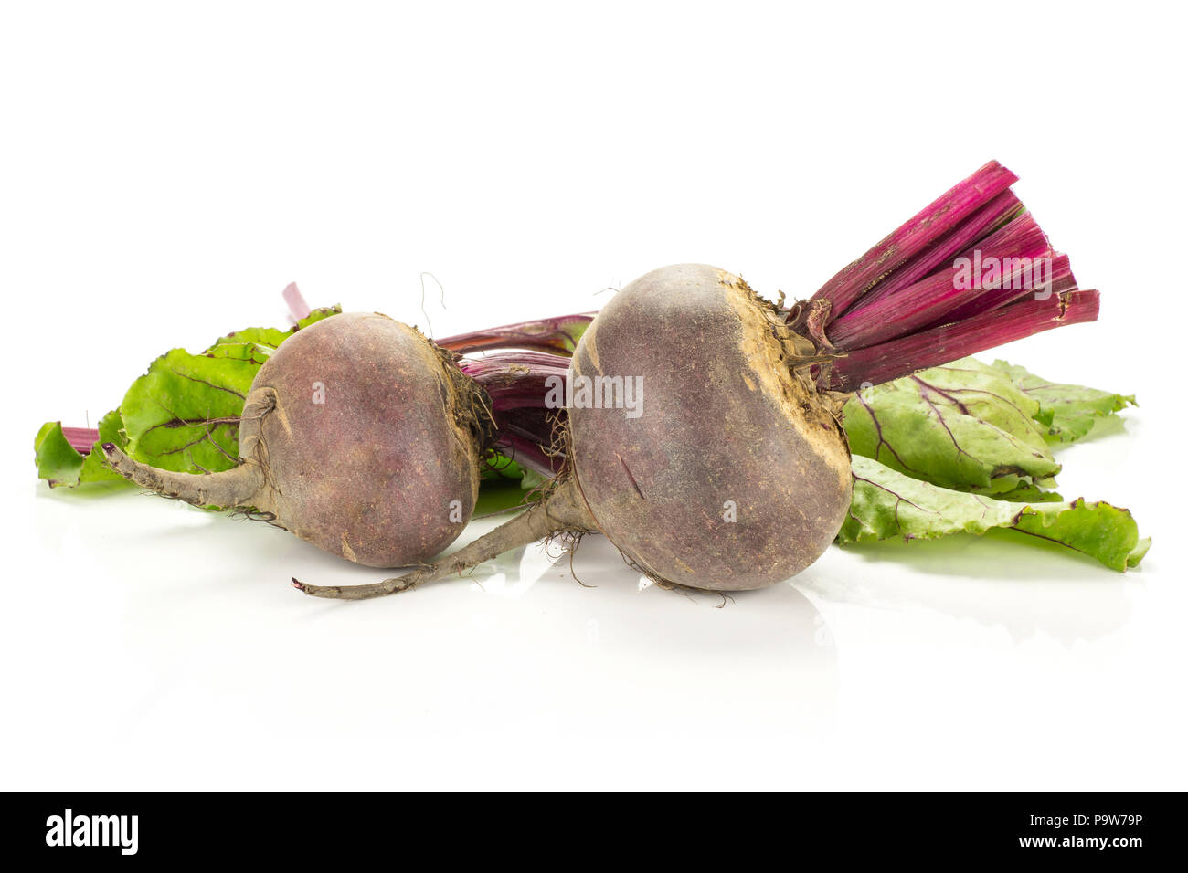 Red beet with cut tops two young bulbs and green leaves isolated on ...