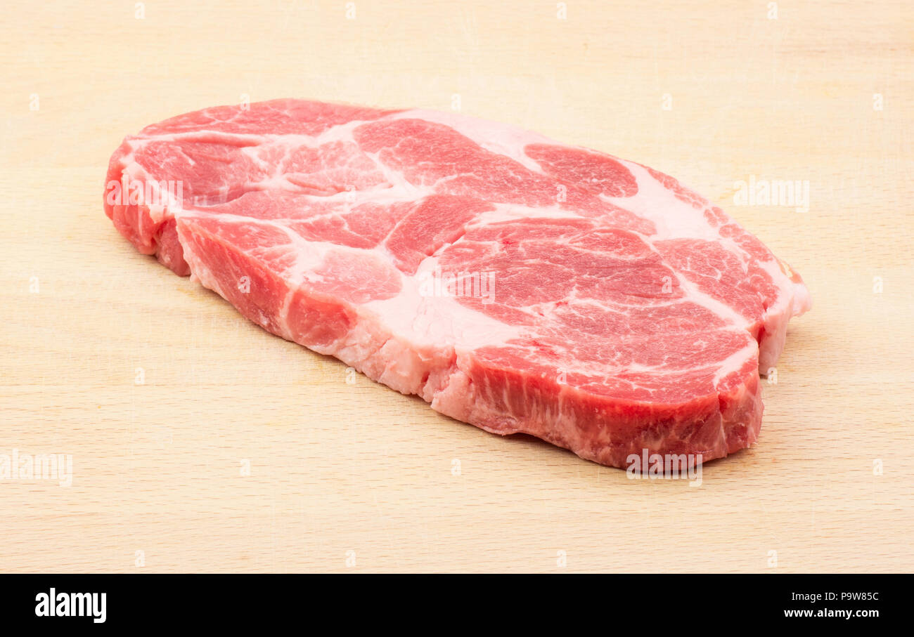 Raw pork neck meat cut isolated on wood background fresh one slice ...