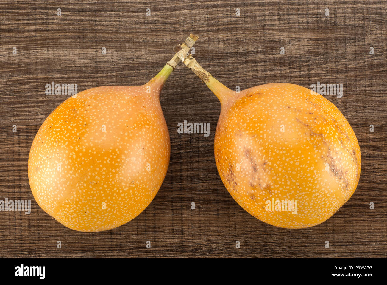 Two giant grenadilla table top isolated on brown wood background sweet ...