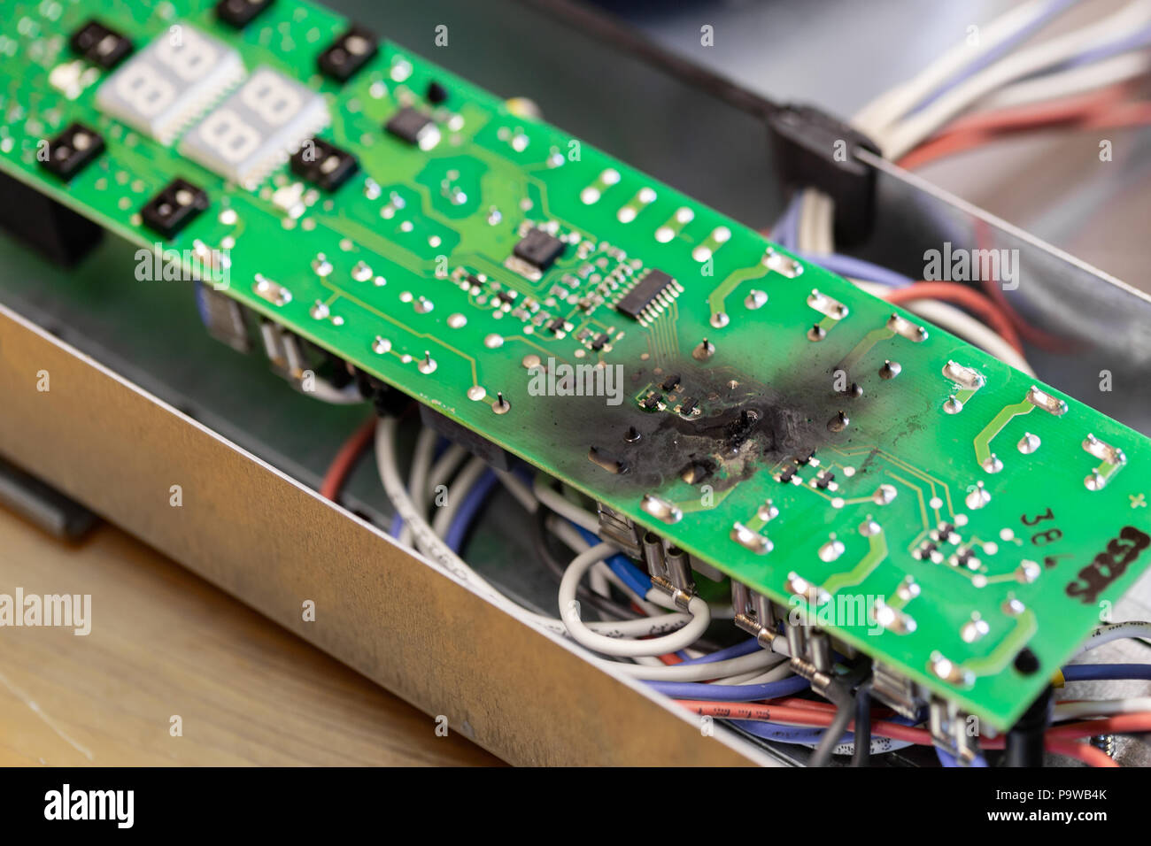 Close up burnt green microchip after short circuit due to water damage ...