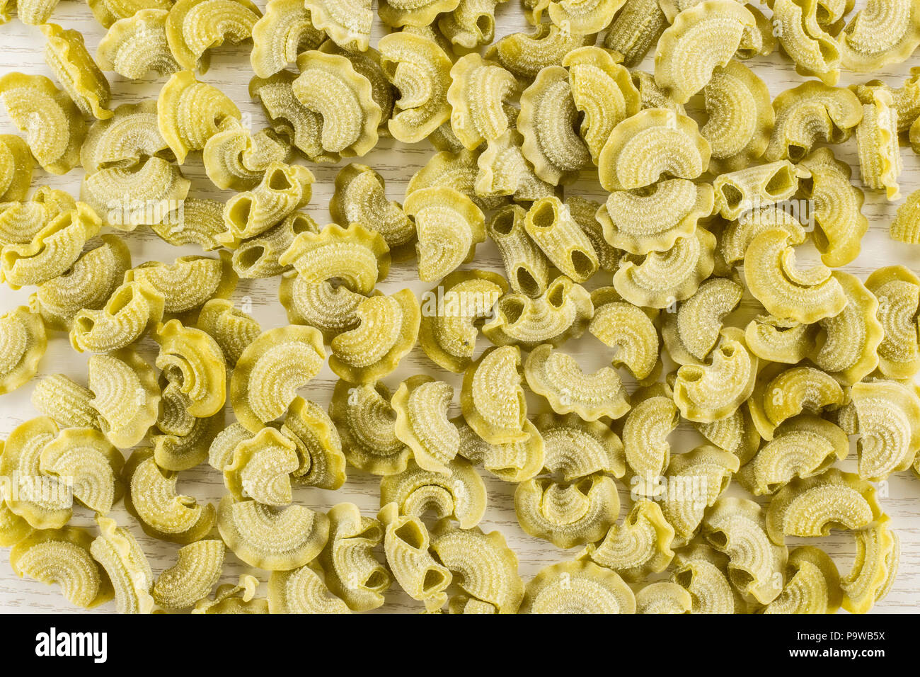 Pasta spinach creste di gallo raw top view isolated on grey wood ...