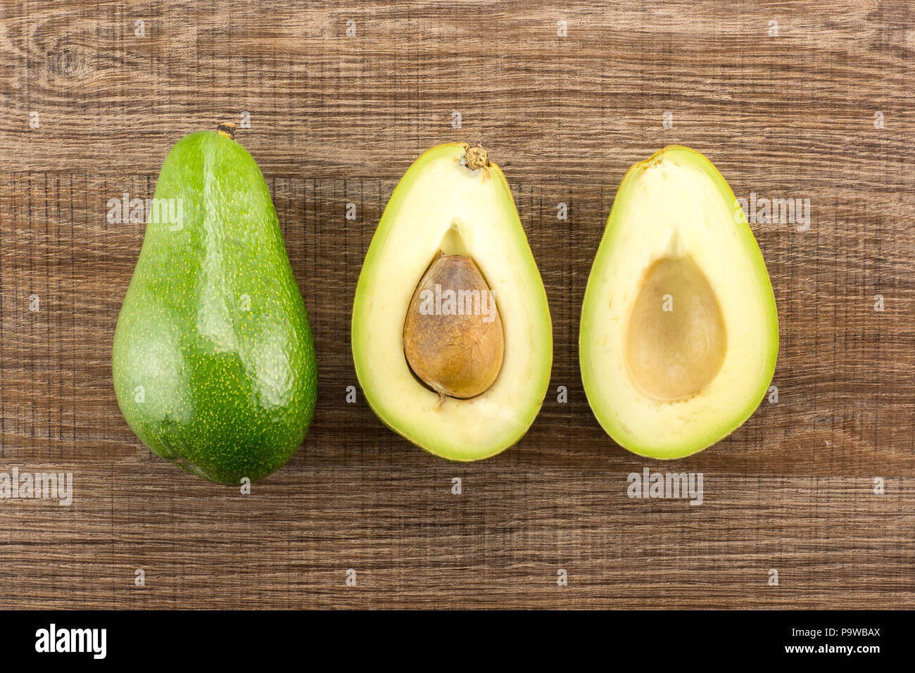 Green smooth avocado collection table top isolated on brown wood ...