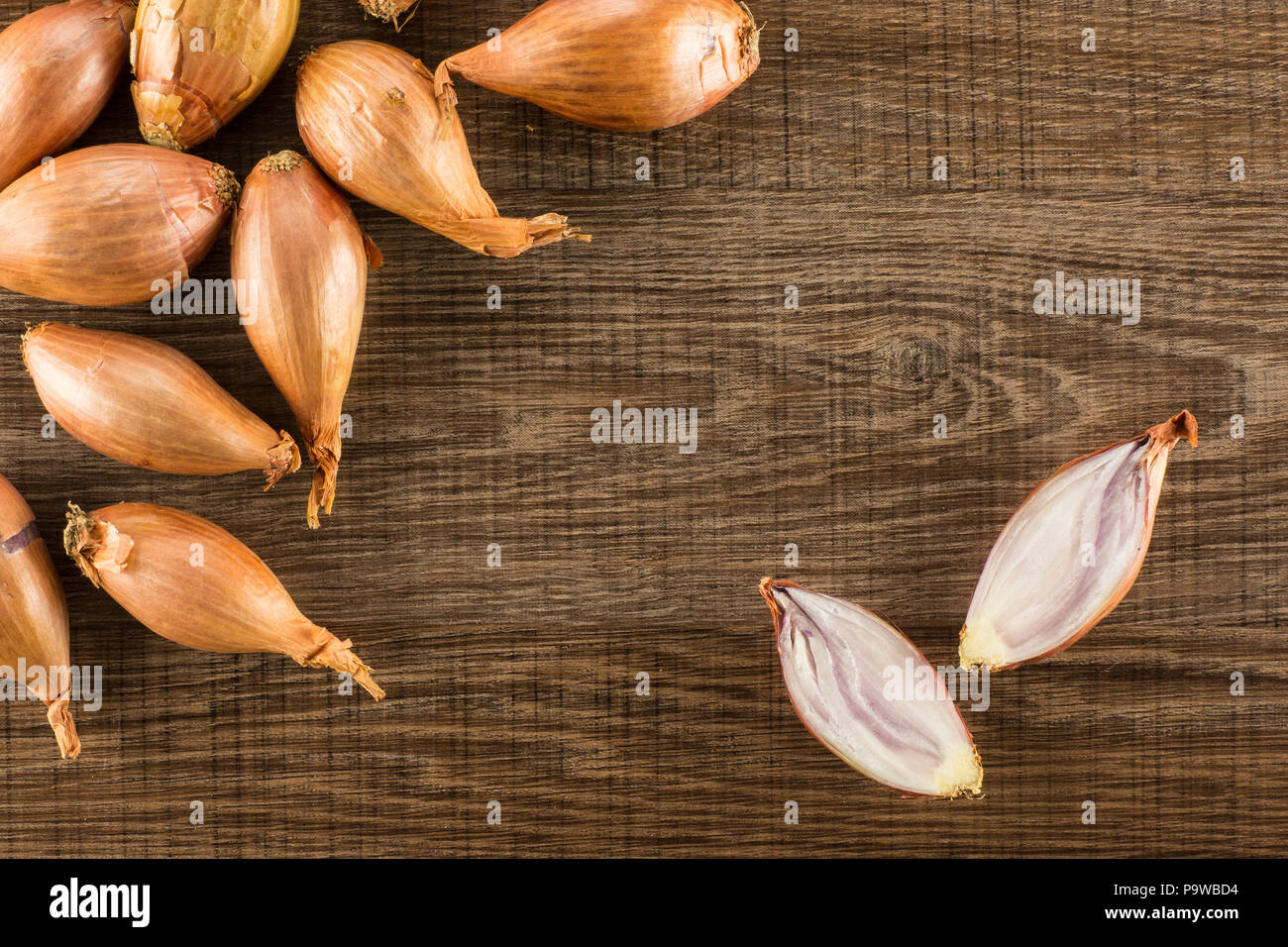Long golden shallots one cut in two halves flatlay isolated on brown ...