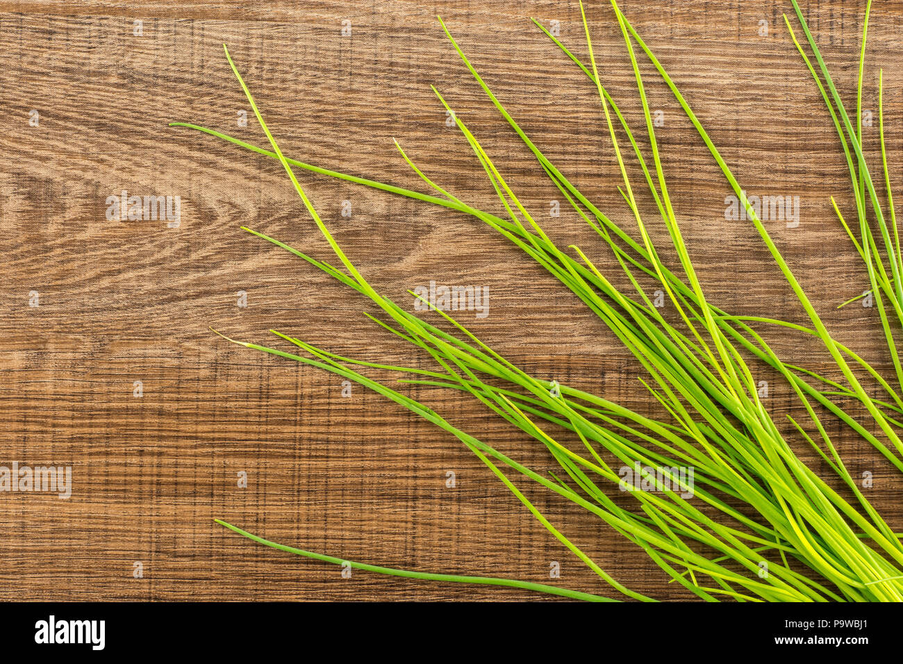 Fresh chives top view isolated on brown wood background grass-like ...