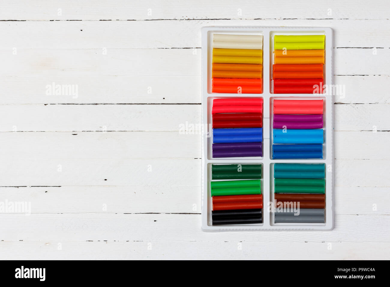 box of wax modeling clay on white wooden background with copy space ...