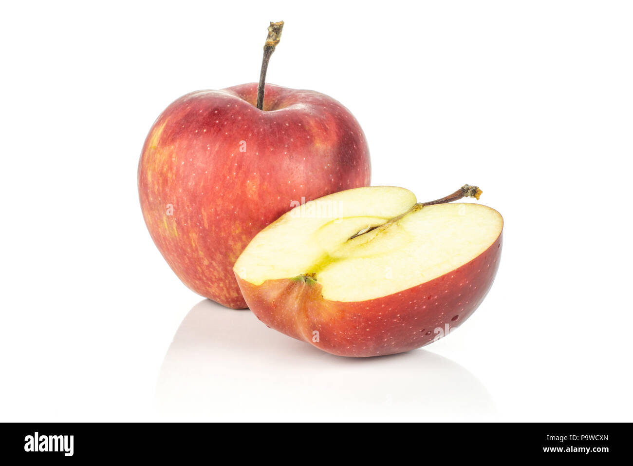 One red delicious apple and a half isolated on white background cross ...