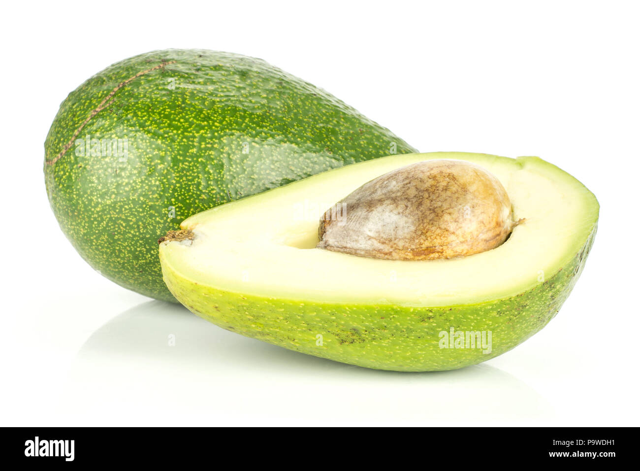 Green smooth avocado and one section half with a seed isolated on white ...