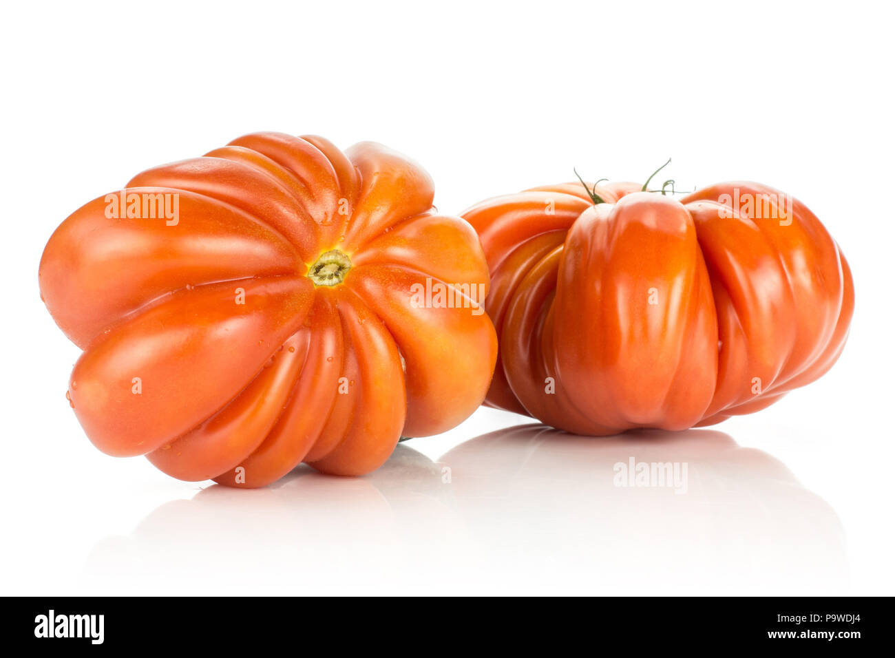 Two beef tomatoes (flower shape) isolated on white background big ripe ...