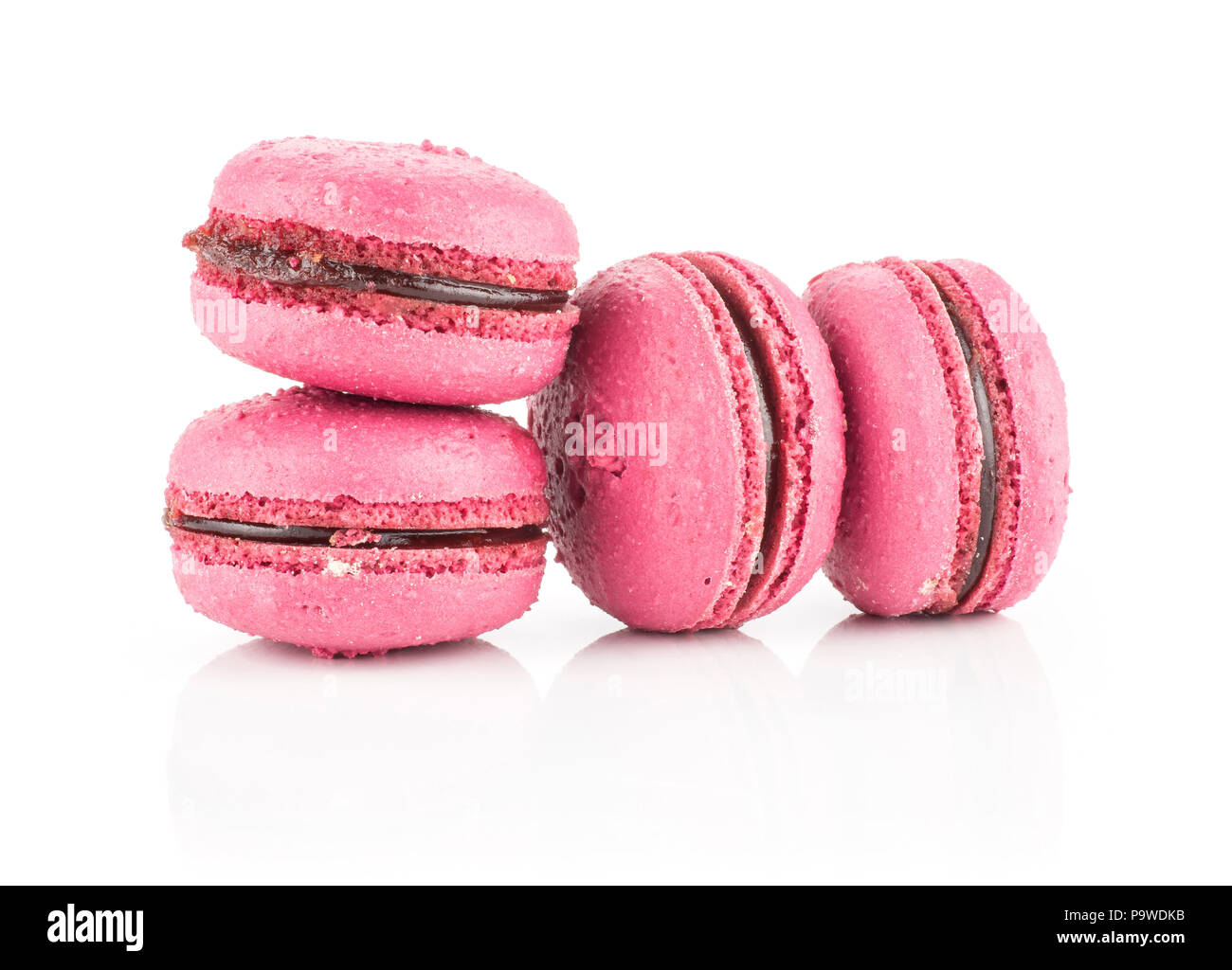 Four pink French macarons with raspberry jam isolated on white ...