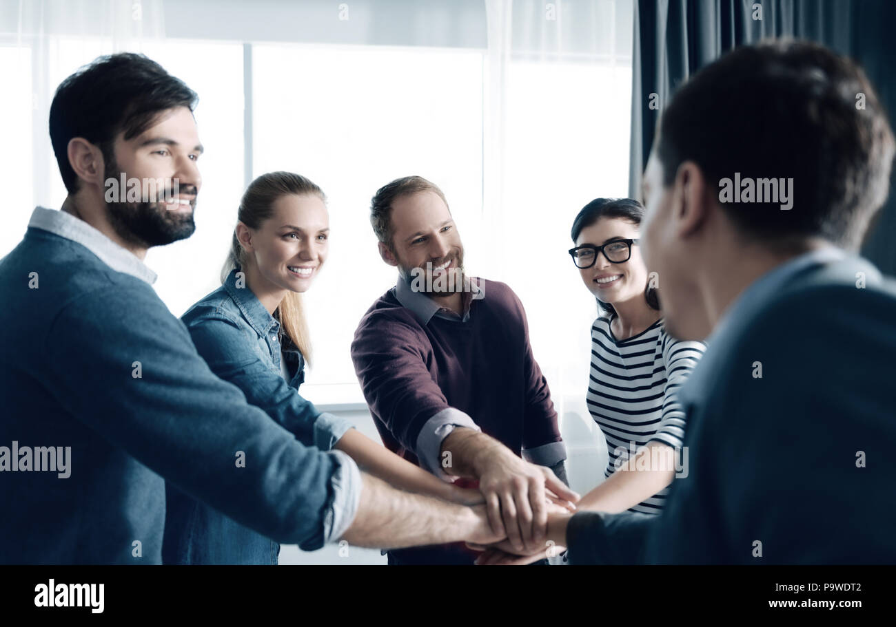 Happy together. Cheerful young group of people smiling and holding ...