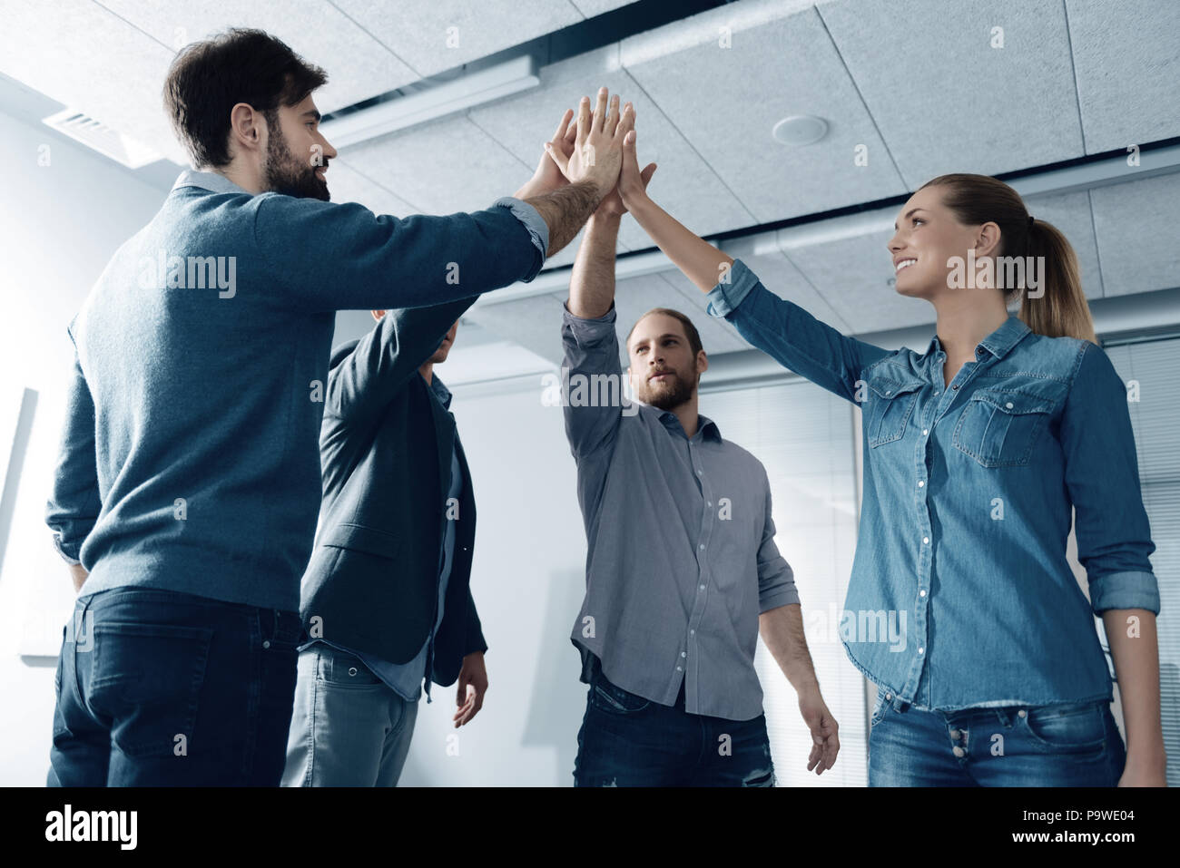 Rely on me. Cheerful young group of people standing in the office and ...