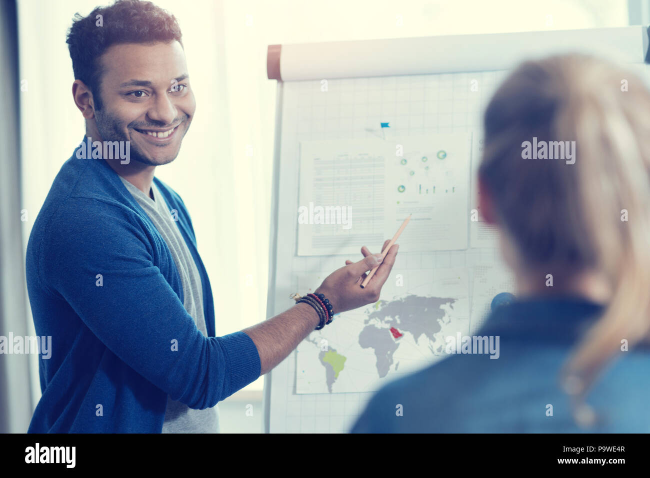 Good idea. Cheerful man keeping smile on his face and standing in semi ...