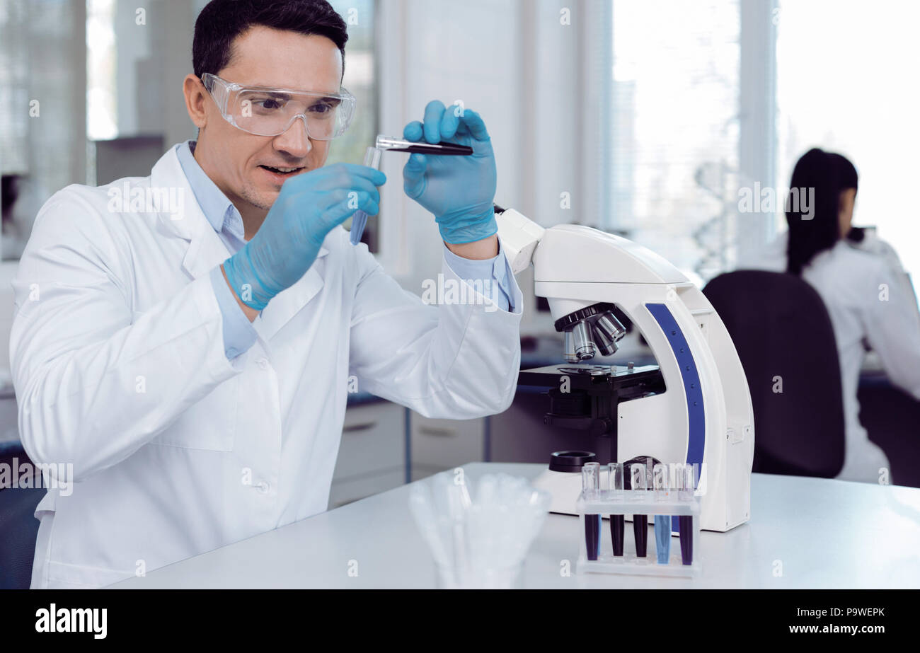 Samples for analysis. Delighted nice male biologist sitting at the ...