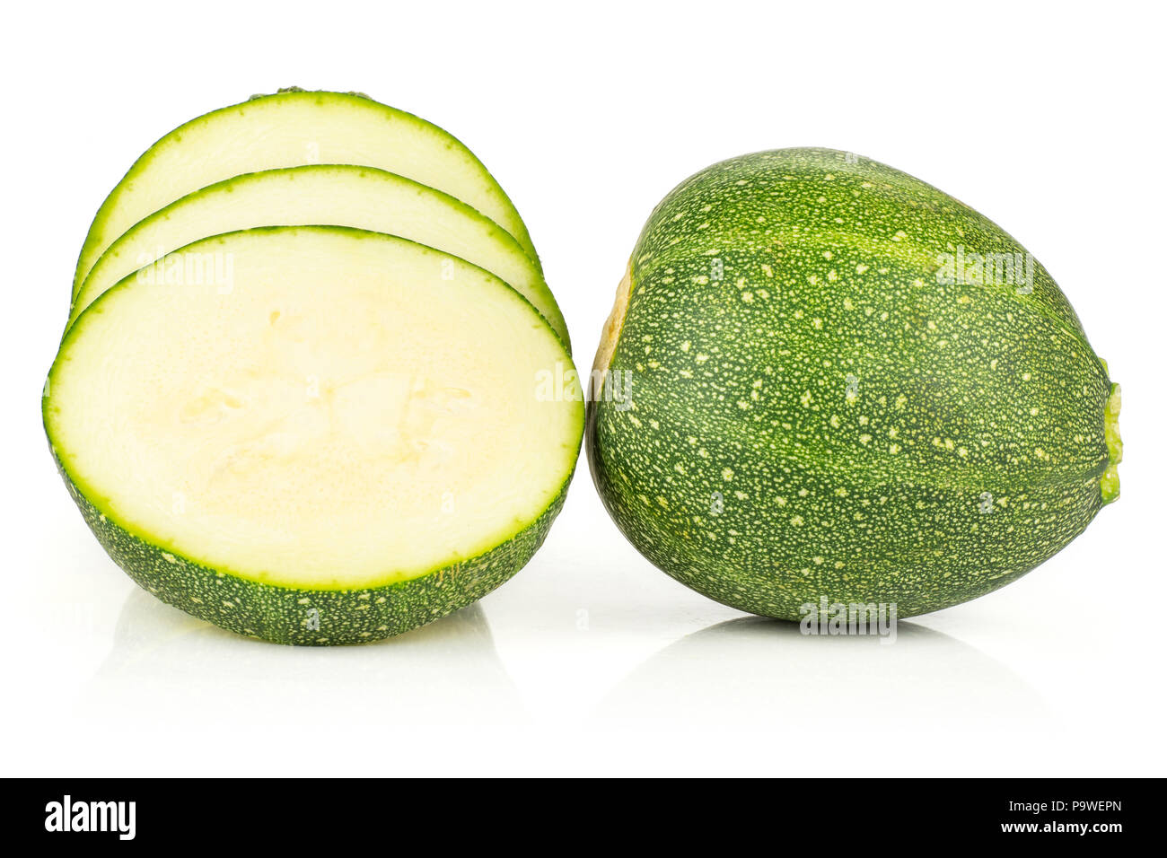 Three slices of round zucchini and one whole isolated on white ...