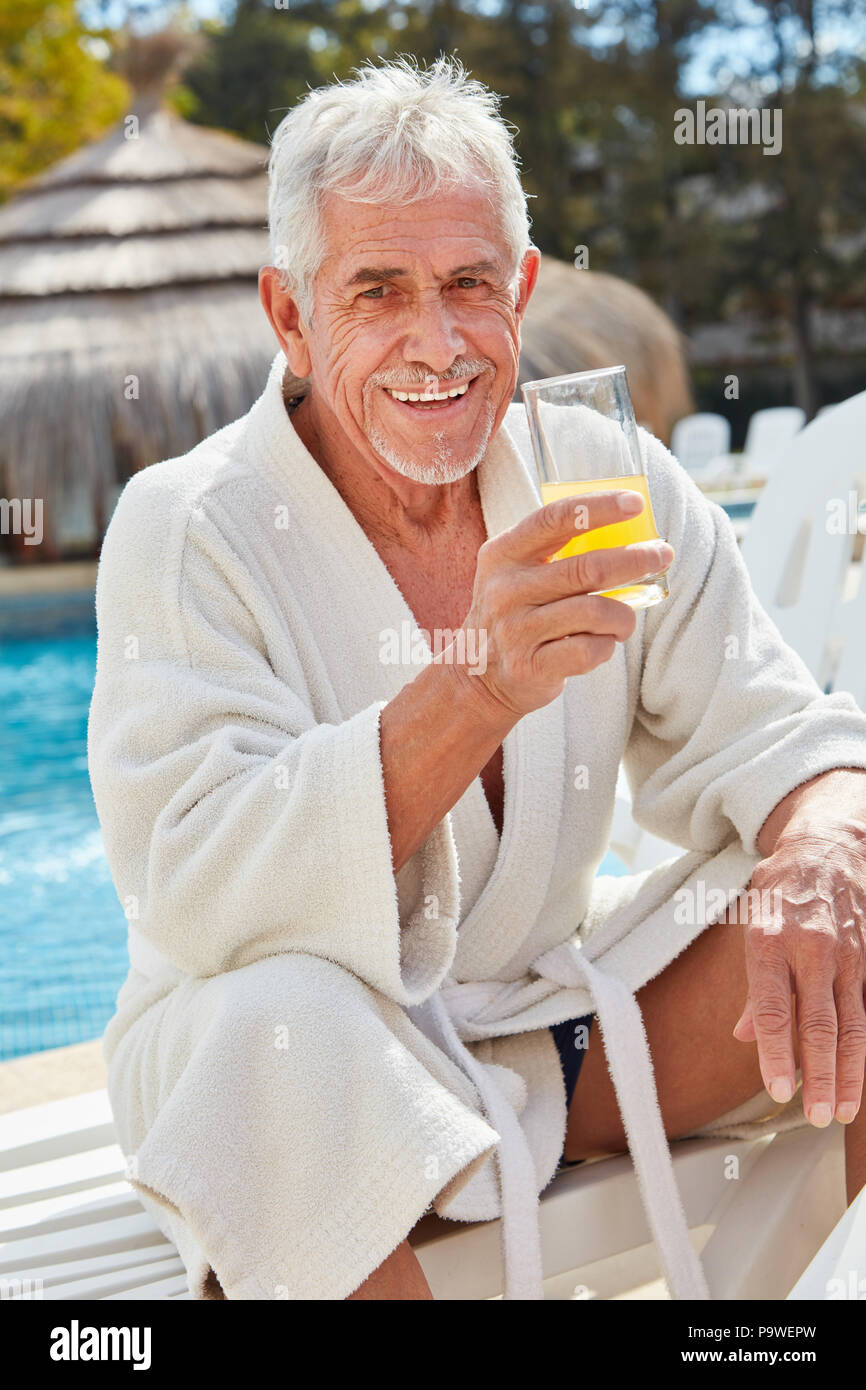 Senior retired manager drinks a juice at the pool in the spa Stock ...