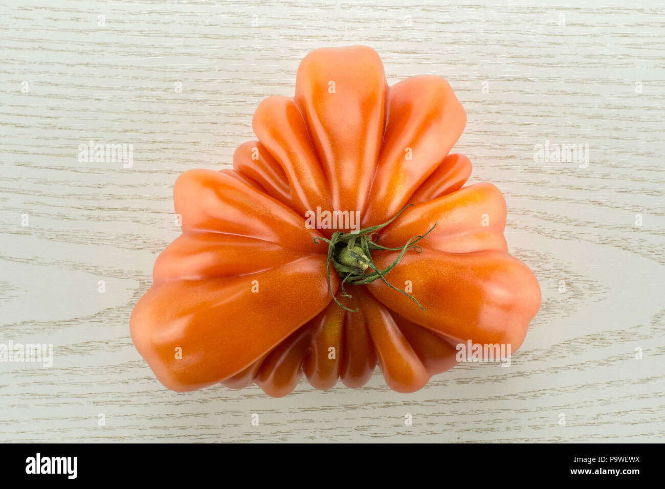 Beef tomato (triangle shape) top view isolated on grey wood background ...