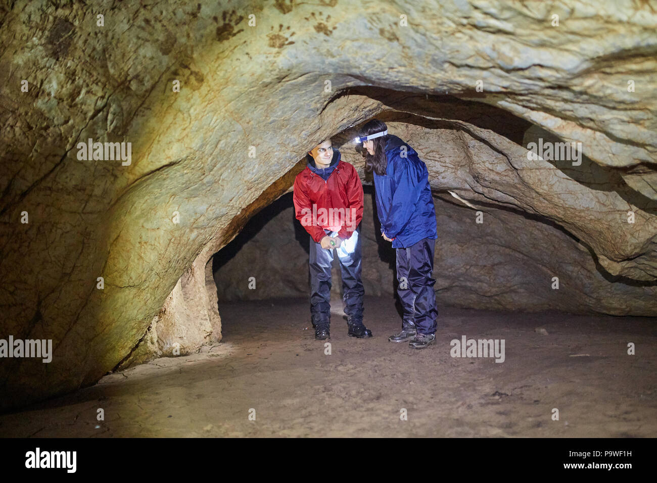 Young couple of hikers exploring a cave in a limestone mountain Stock ...