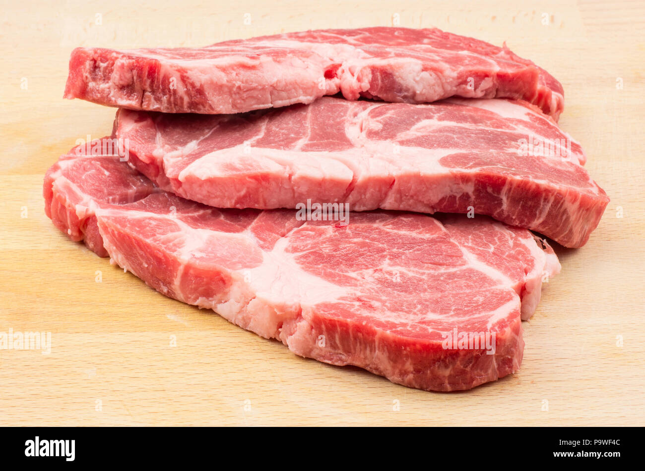 Raw pork neck three meat cuts isolated on wood background fresh slices ...