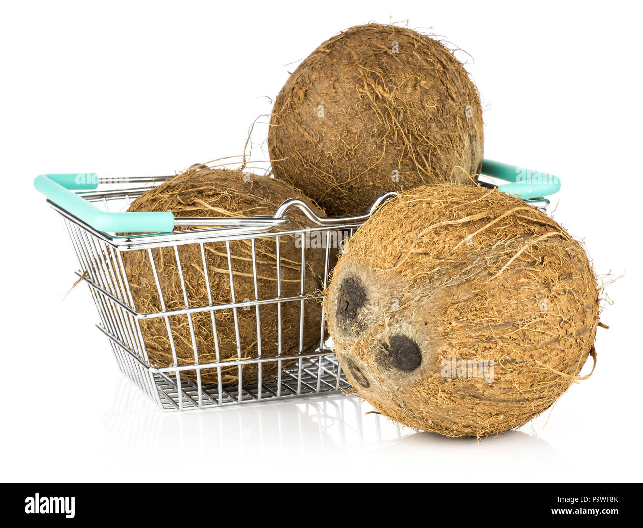 Three coconuts in a shopping basket isolated on white background brown ...