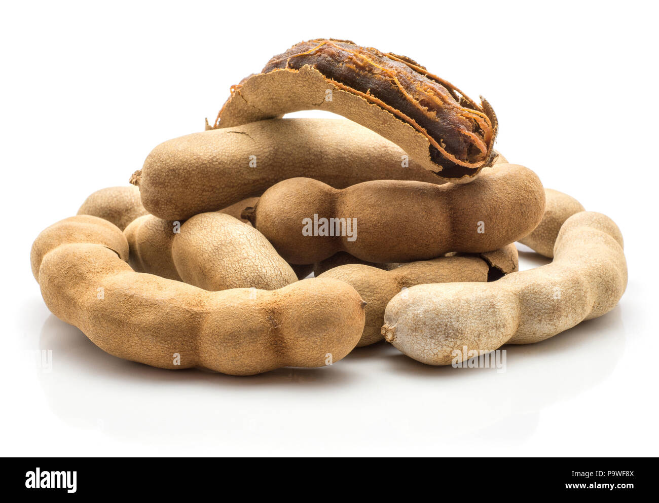 Brown tamarind set with a cracked one on top isolated on white ...