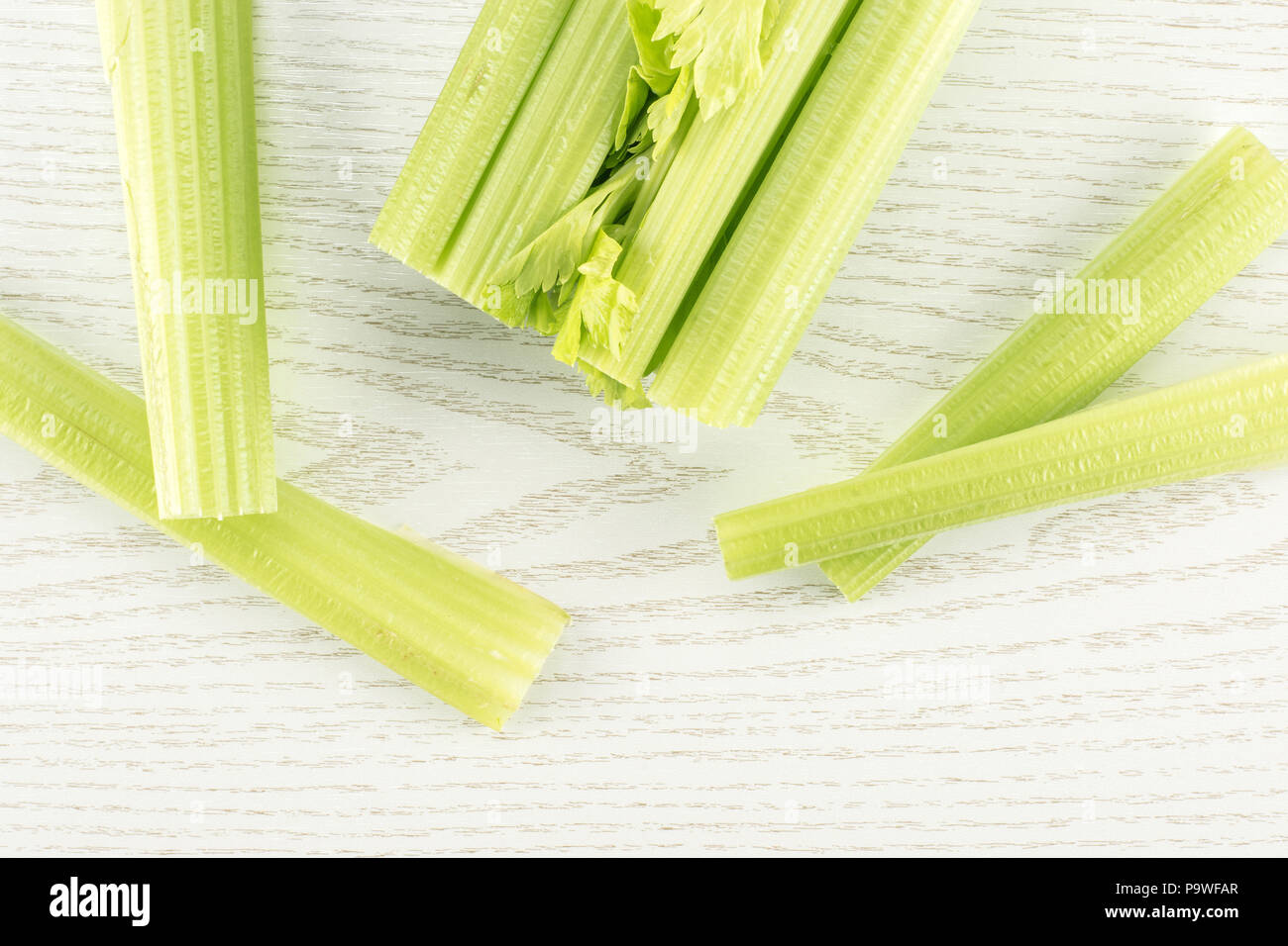 One fresh green celery with four sticks isolated on light wooden ...