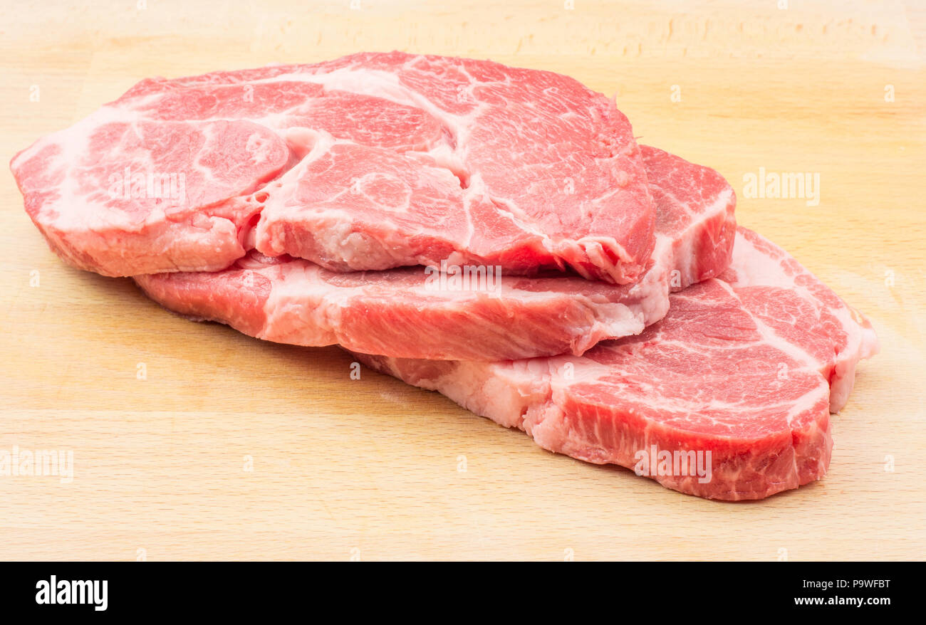 Raw pork neck meat cuts top view isolated on wood background fresh ...
