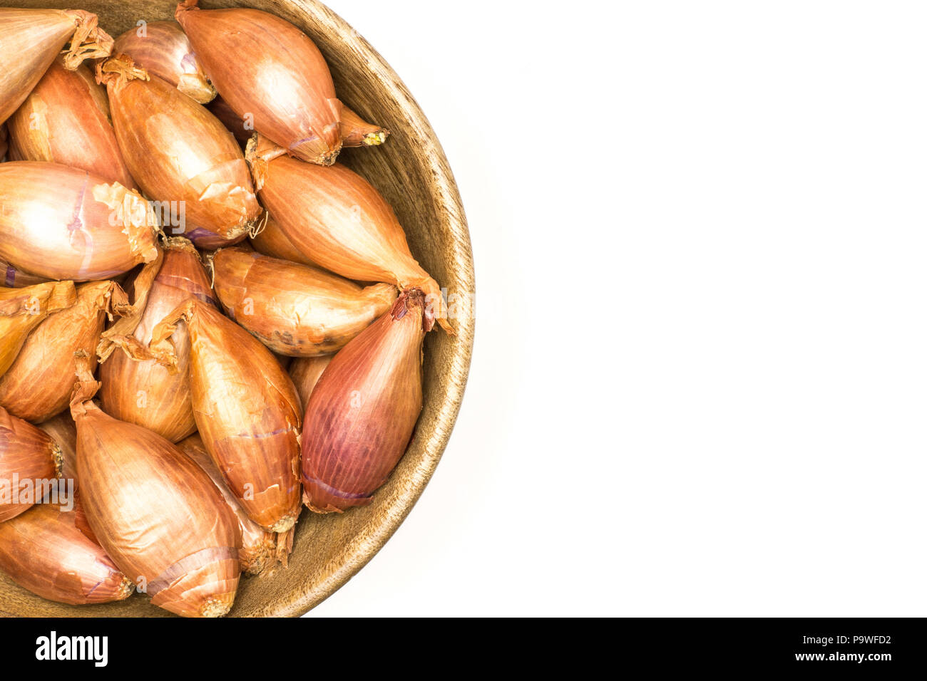 Long shallot in a wooden bowl flatlay isolated on white background ...