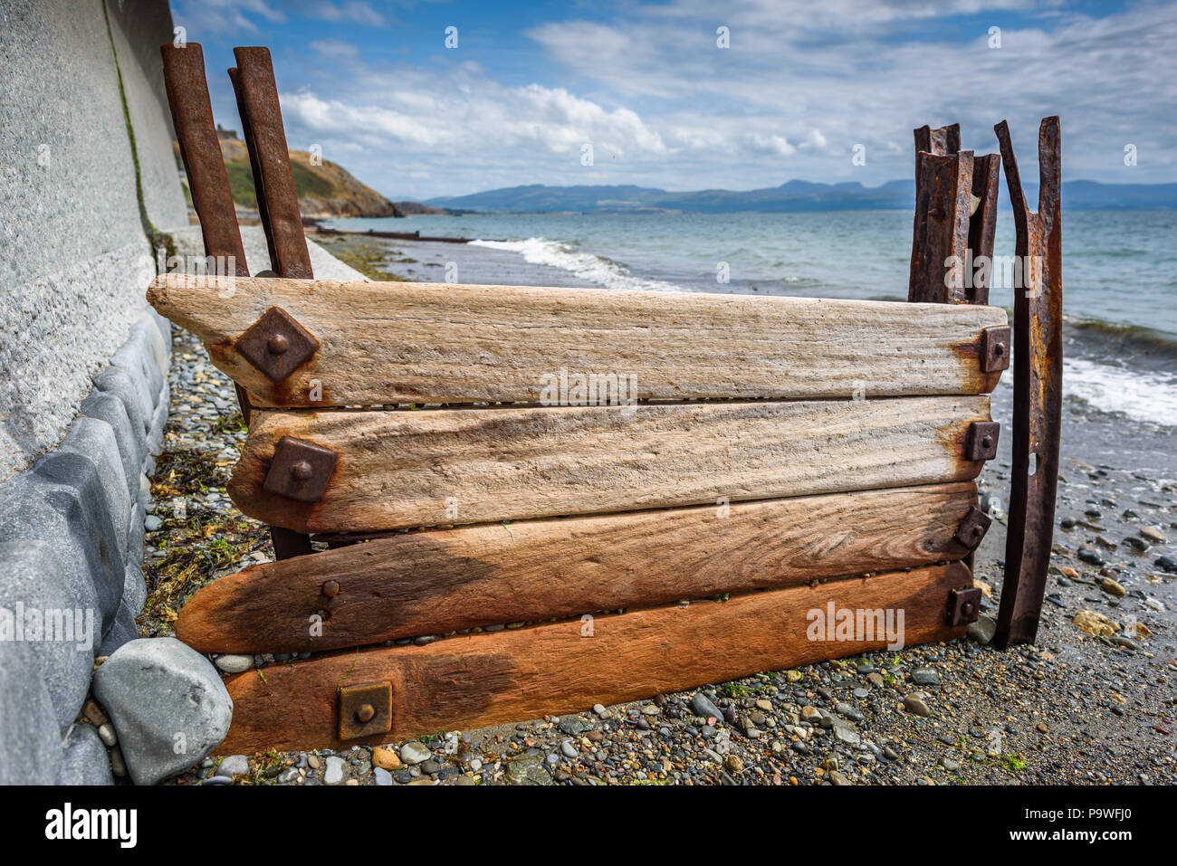 Weathered wooden groynes and rusting metal to protect the sea coast at ...