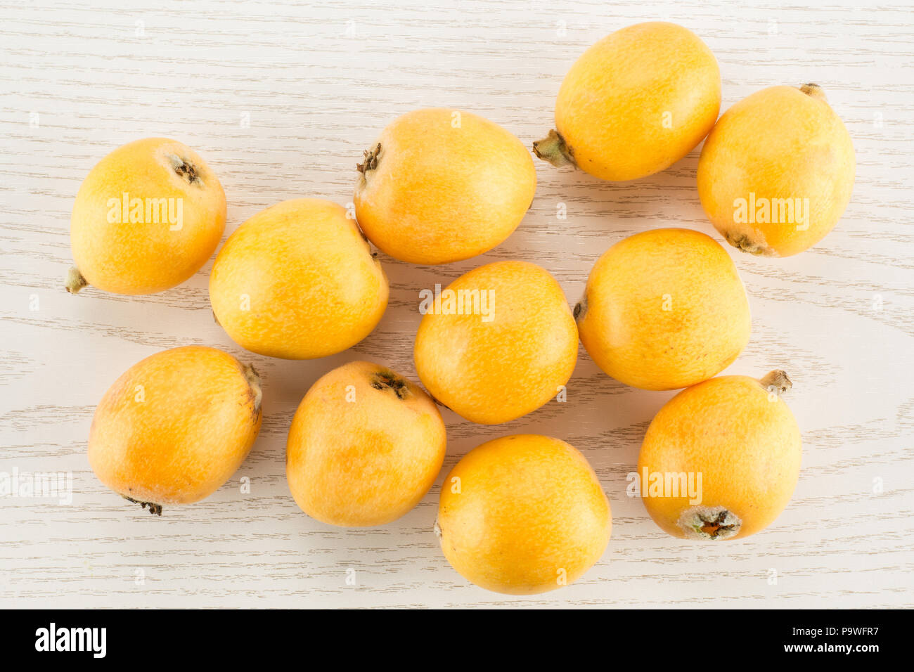Fresh orange Japanese loquats top view isolated on grey wood background ...