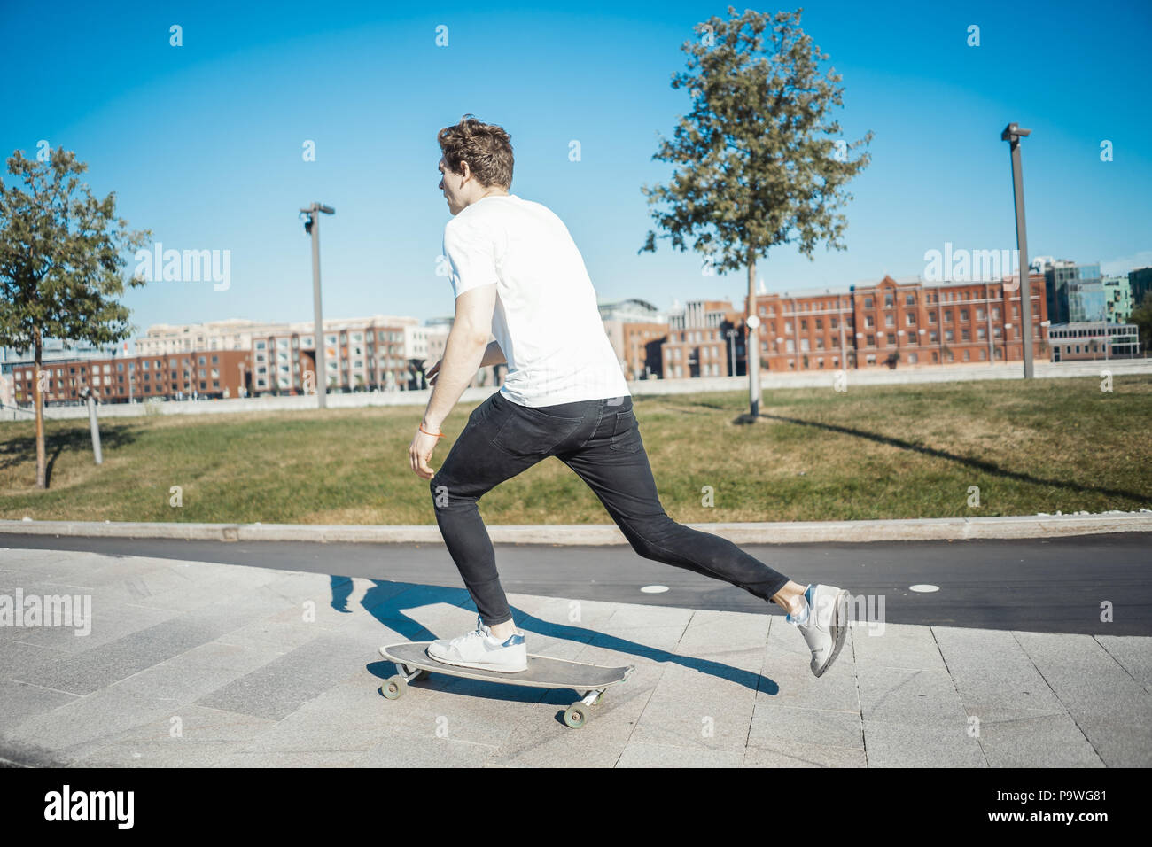 Young attractive man riding longboard in the park Stock Photo - Alamy
