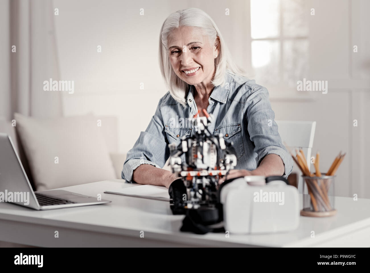 Future coming. Grandma tapping robot wondering about its functions ...