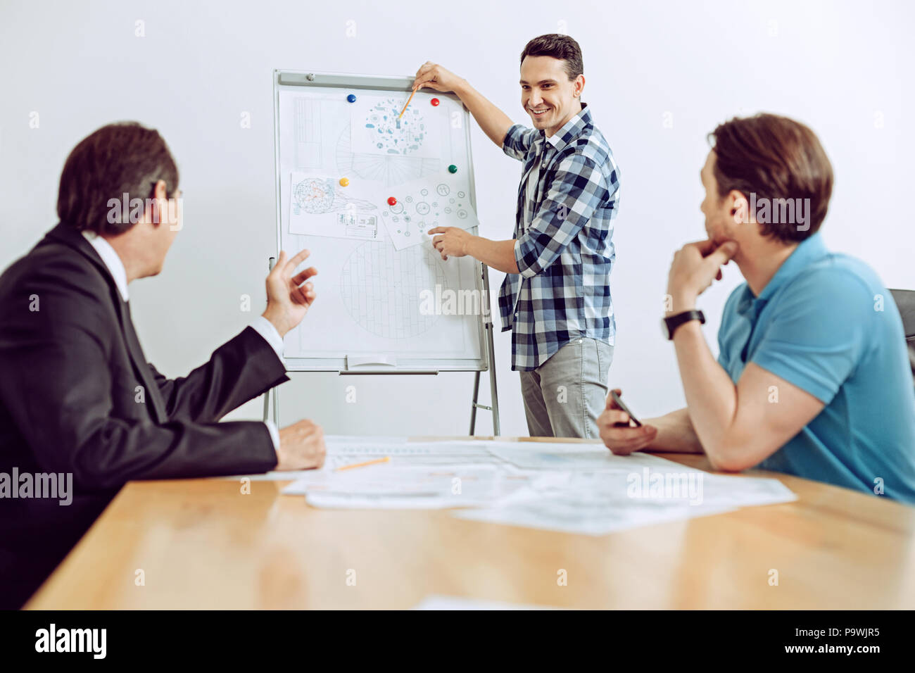 Colorful diagrams. Cheerful emotional happy engineer showing bright ...