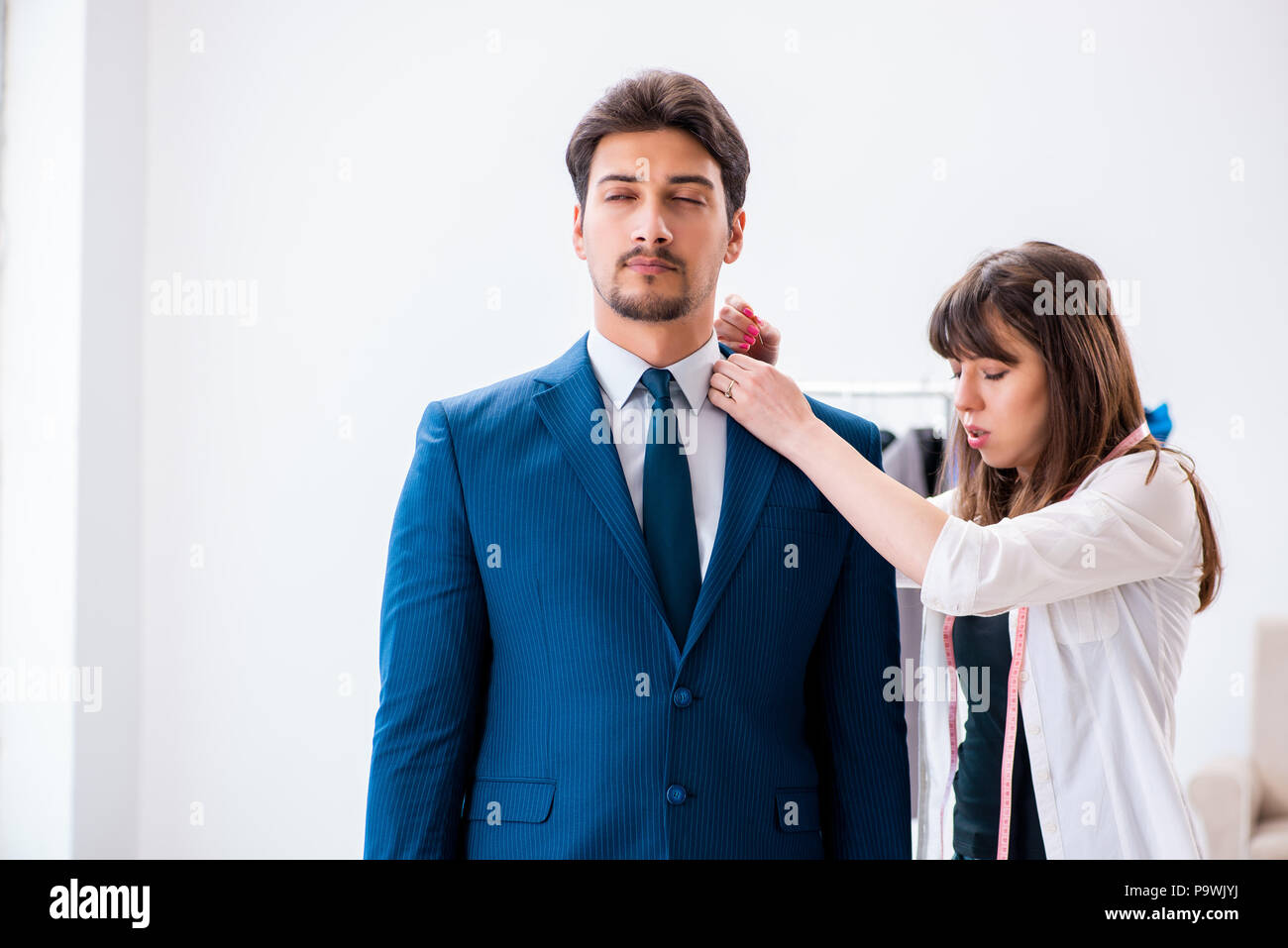 Professional tailor taking measurements for formal suit Stock Photo - Alamy