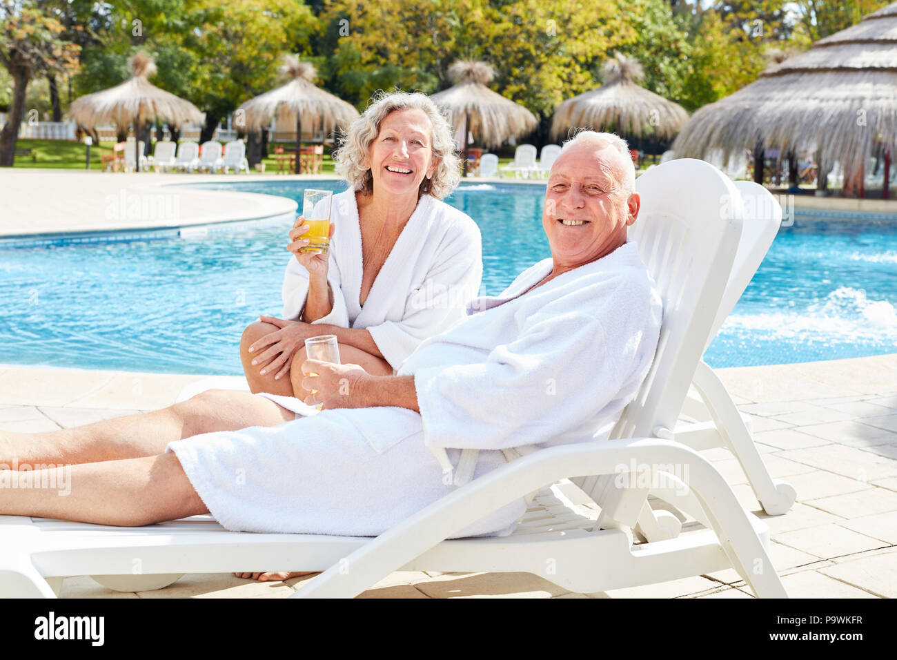 Happy seniors couple relaxing at the swimming pool of luxury spa hotel ...