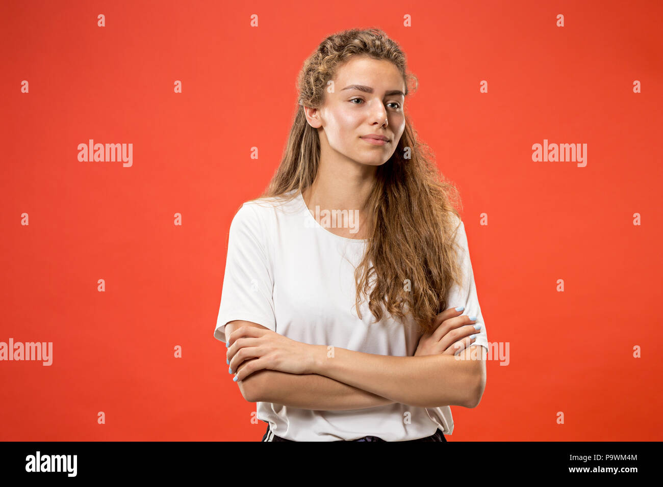 The happy woman standing and smiling against red background Stock Photo ...