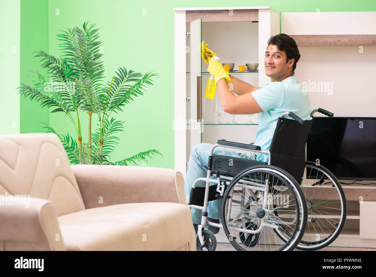 Disabled man on wheelchair cleaning house Stock Photo - Alamy