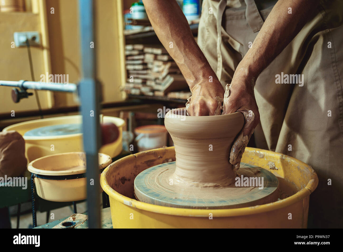 Creating a jar or vase of white clay close-up. Master crock. Man hands ...