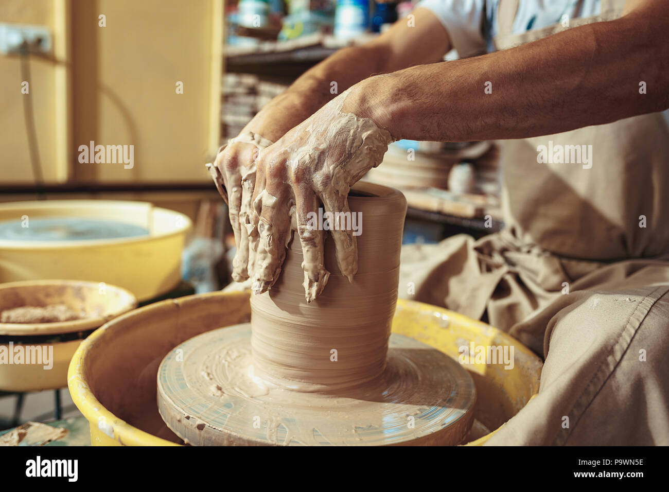 Creating a jar or vase of white clay close-up. Master crock. Man hands ...