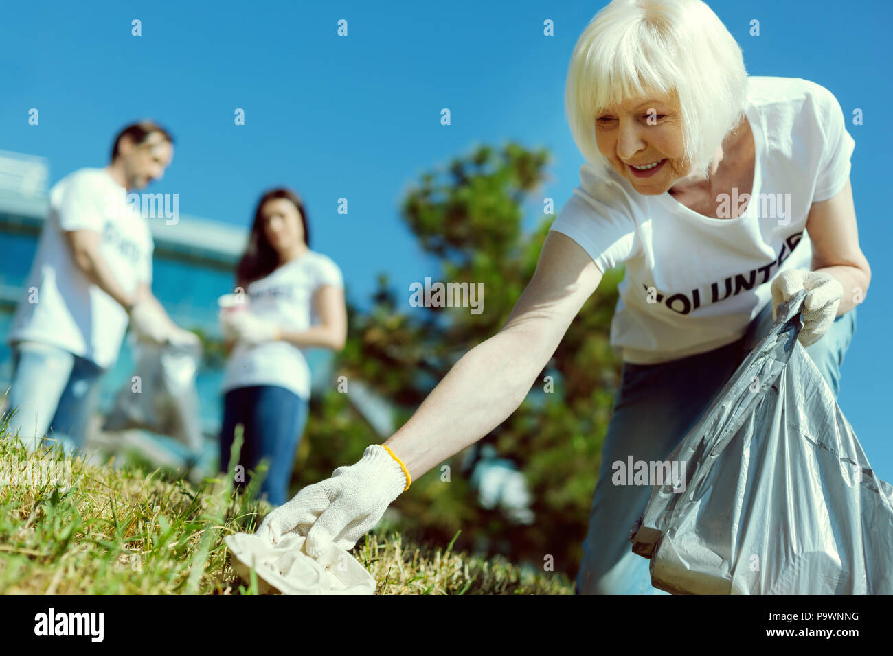 Positive delighted female gathering plastic Stock Photo - Alamy