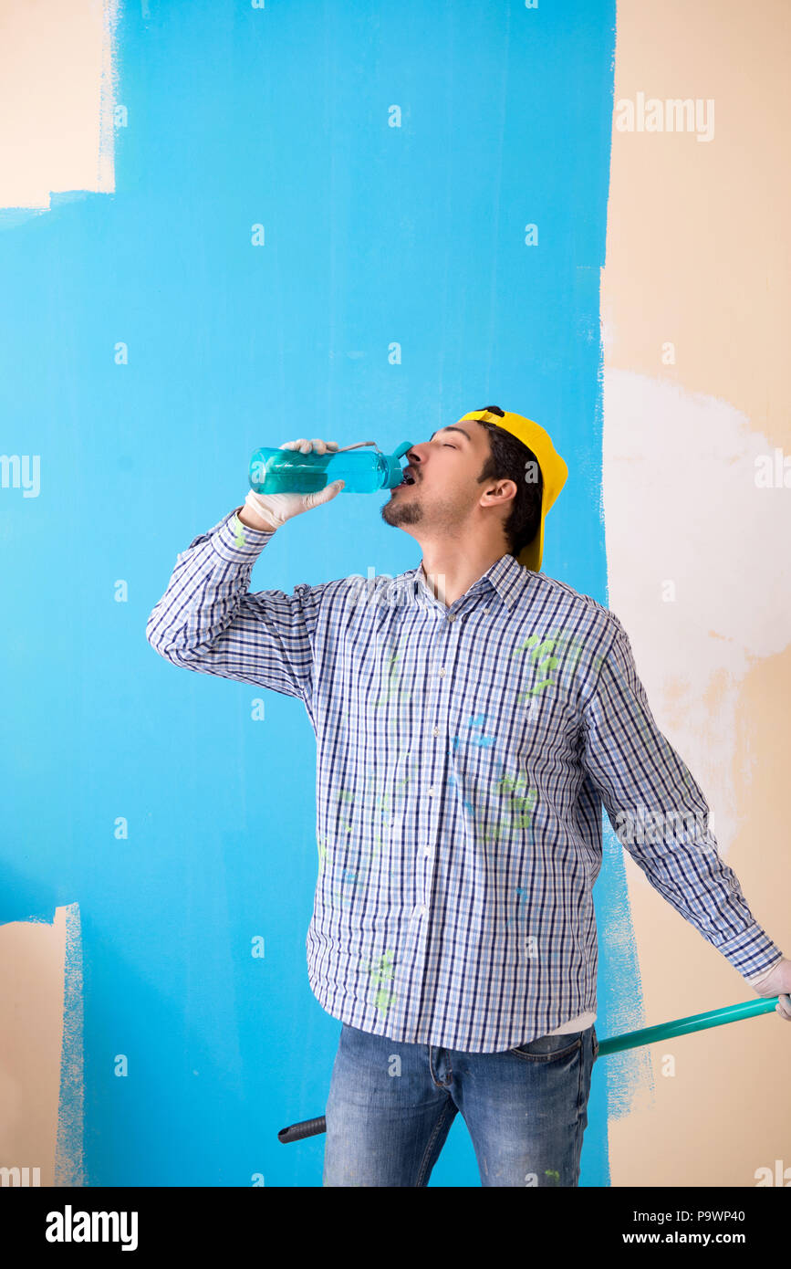 Painter man painting the wall at home Stock Photo - Alamy