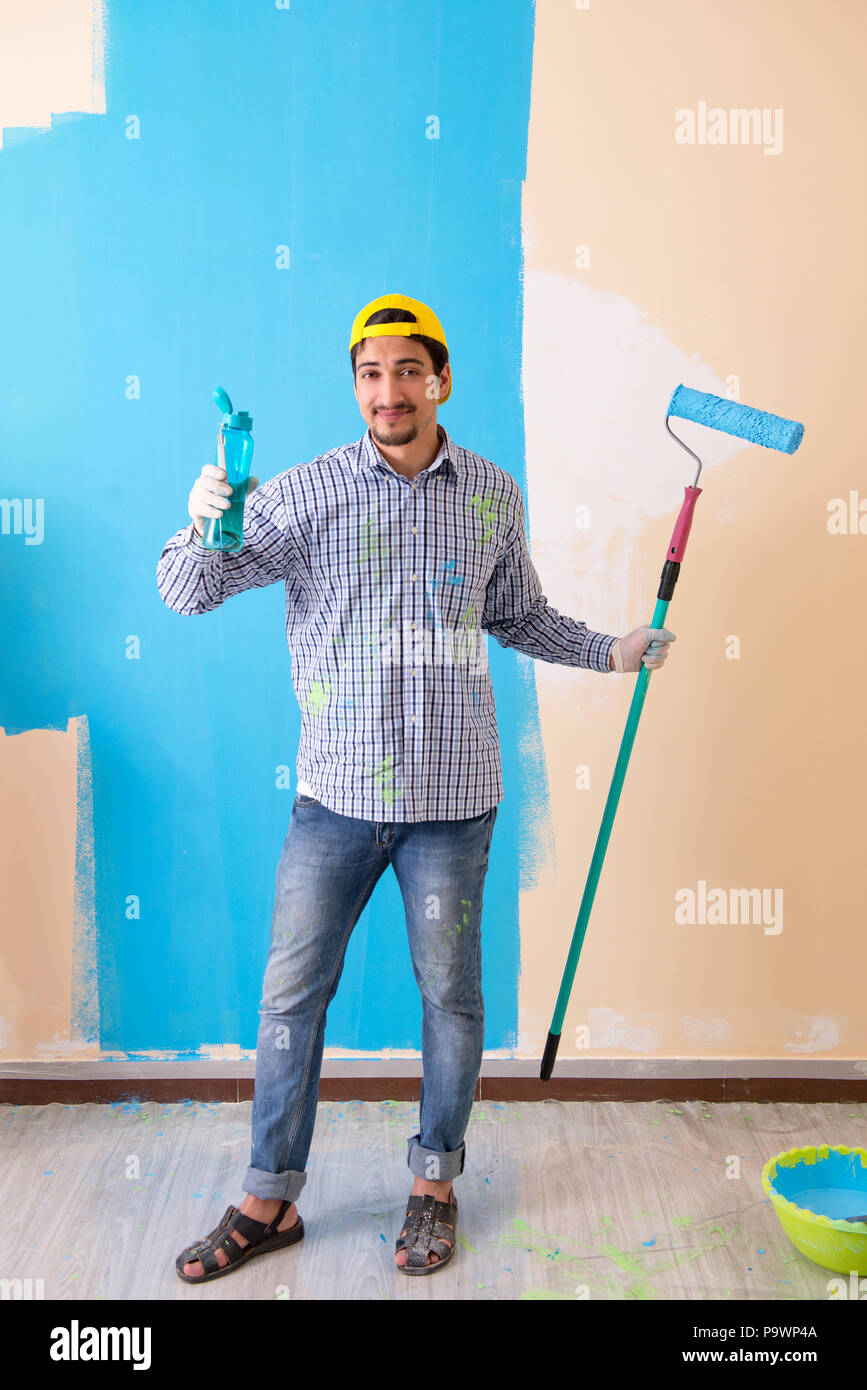 Painter man painting the wall at home Stock Photo - Alamy