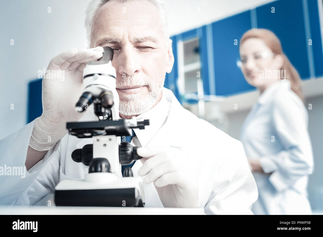 Smart handsome biologist looking into the microscope Stock Photo - Alamy