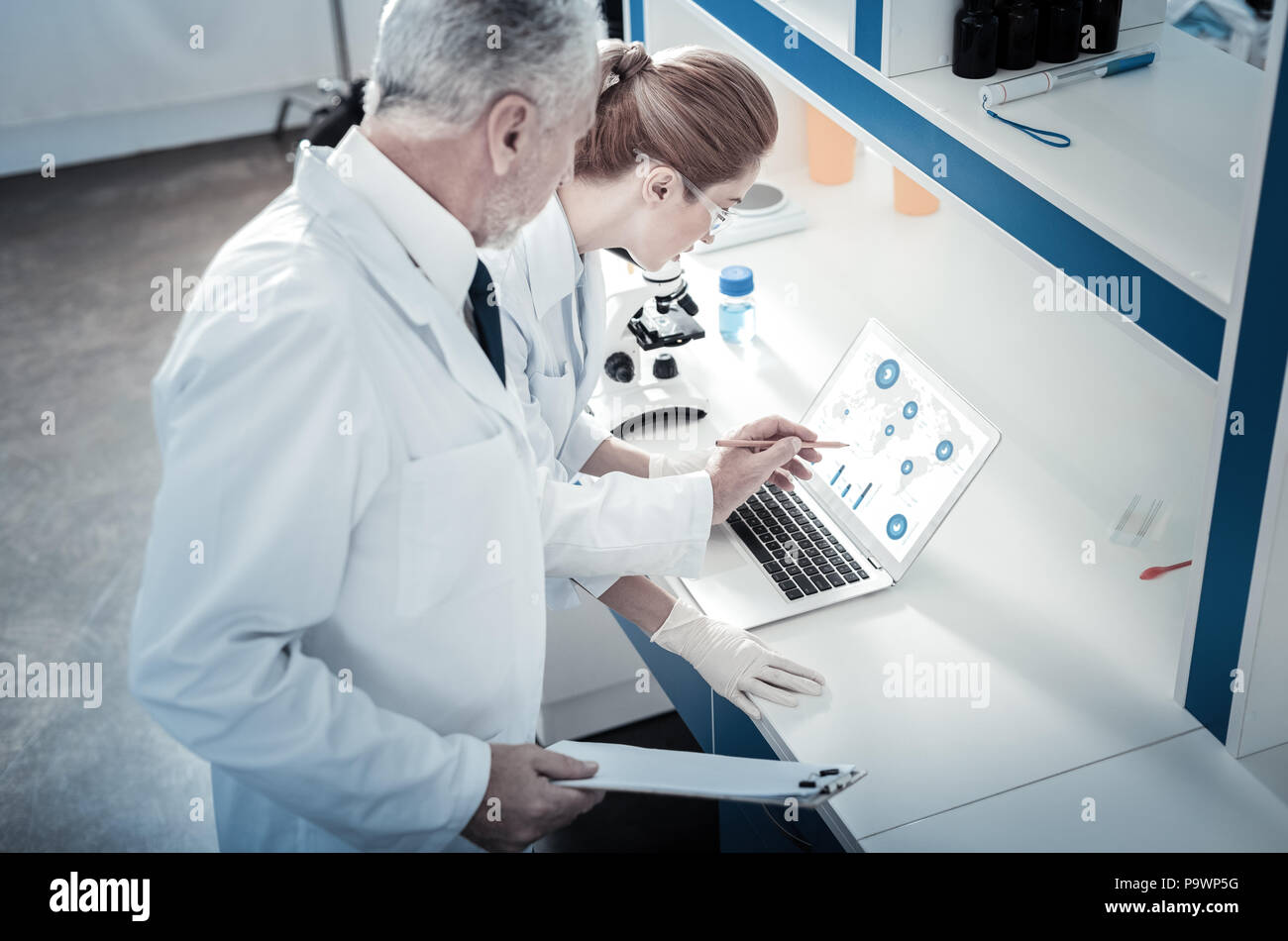 Serious male scientist holding a pencil Stock Photo - Alamy