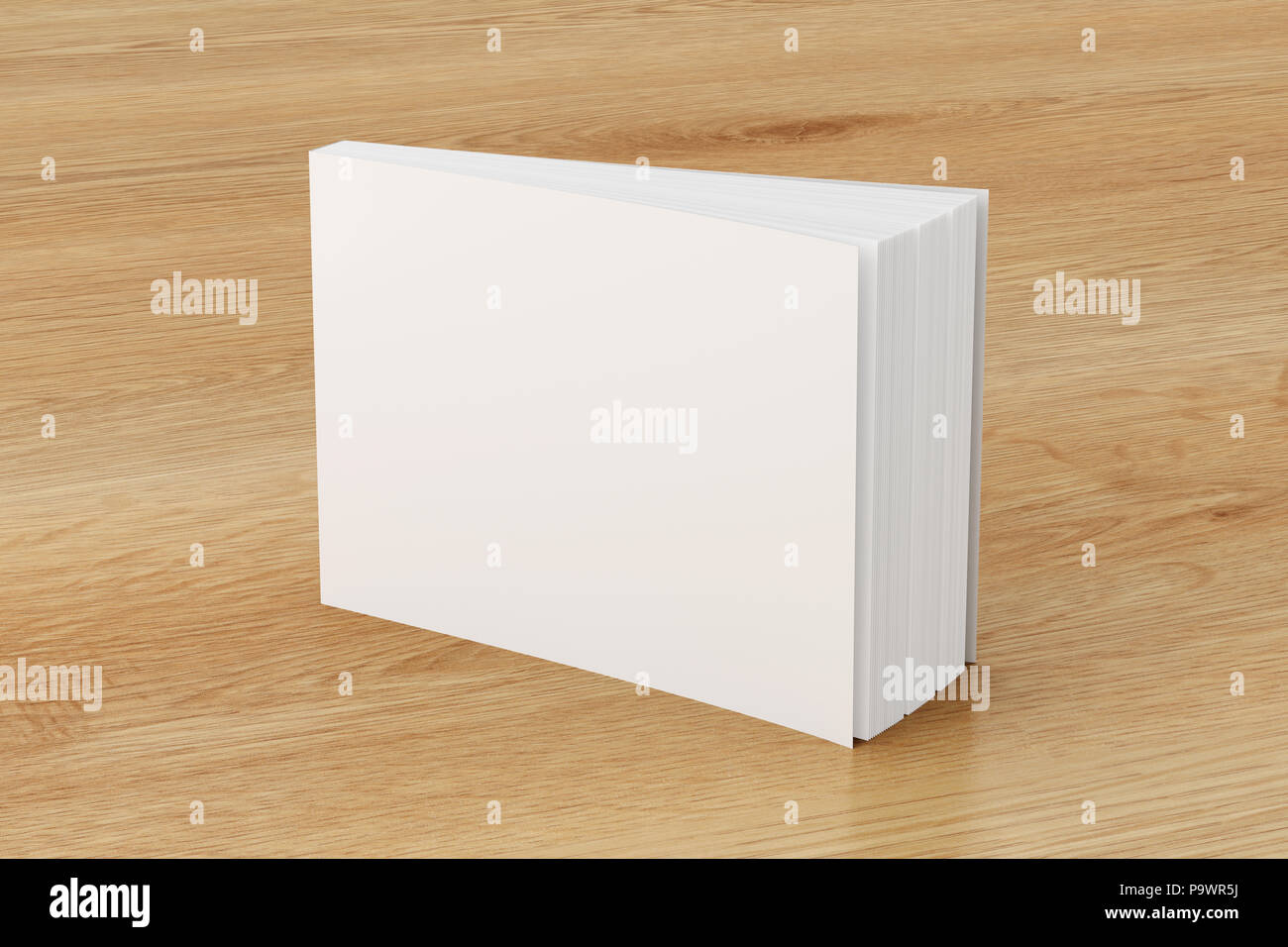Blank white horizontal soft cover book standing on wooden background ...