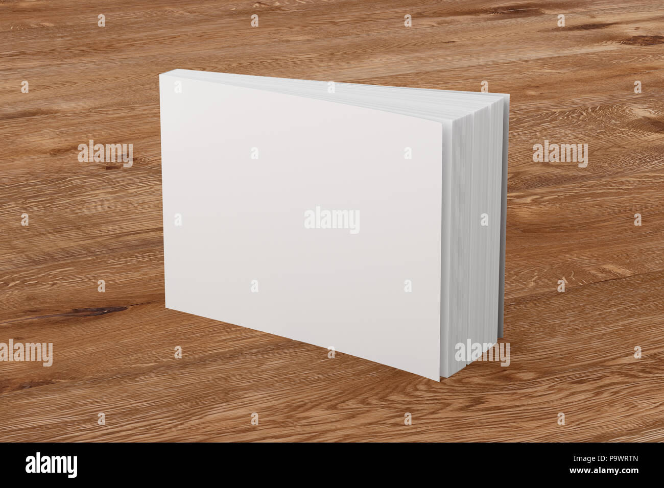 Blank white horizontal soft cover book standing on wooden background ...