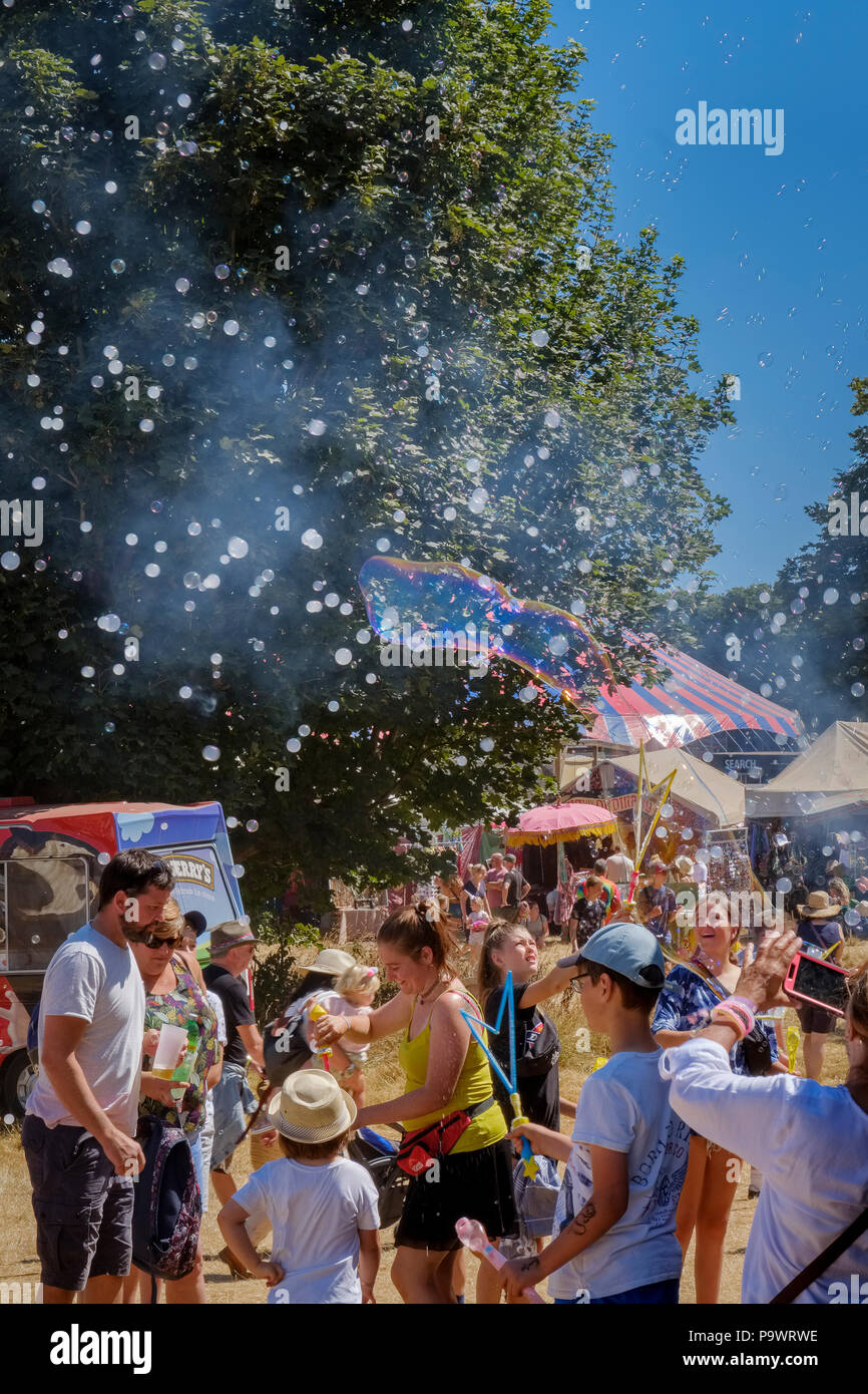 Young women making bubbles, bubbles floating in the air, woman taking ...