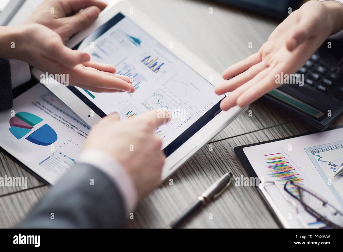 Businessman on online Financial Assessment on a tablet . Team work in ...