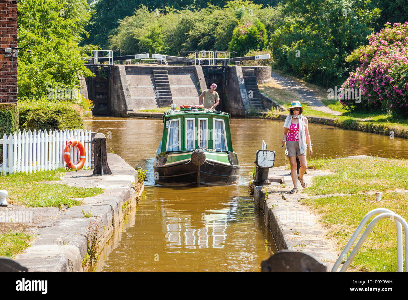 Canal narrowboat passing through locks on the Trent and Mersey canal as ...
