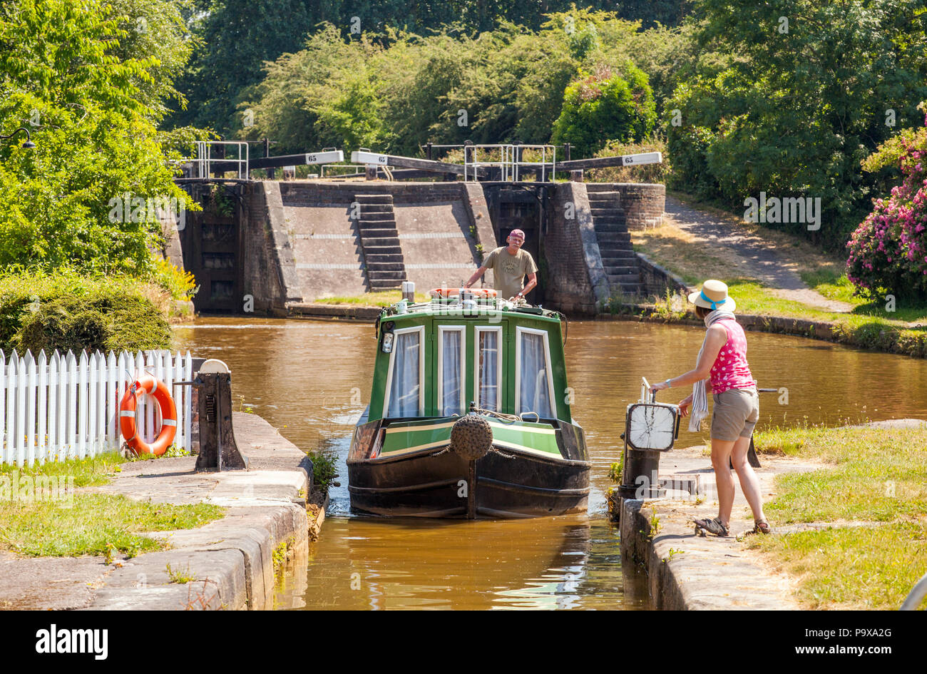 Canal narrowboat passing through locks on the Trent and Mersey canal as ...