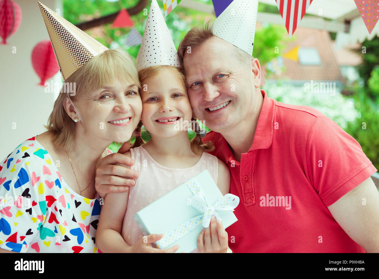 Portrait of happy grandparents celebrating birthday with their pretty ...